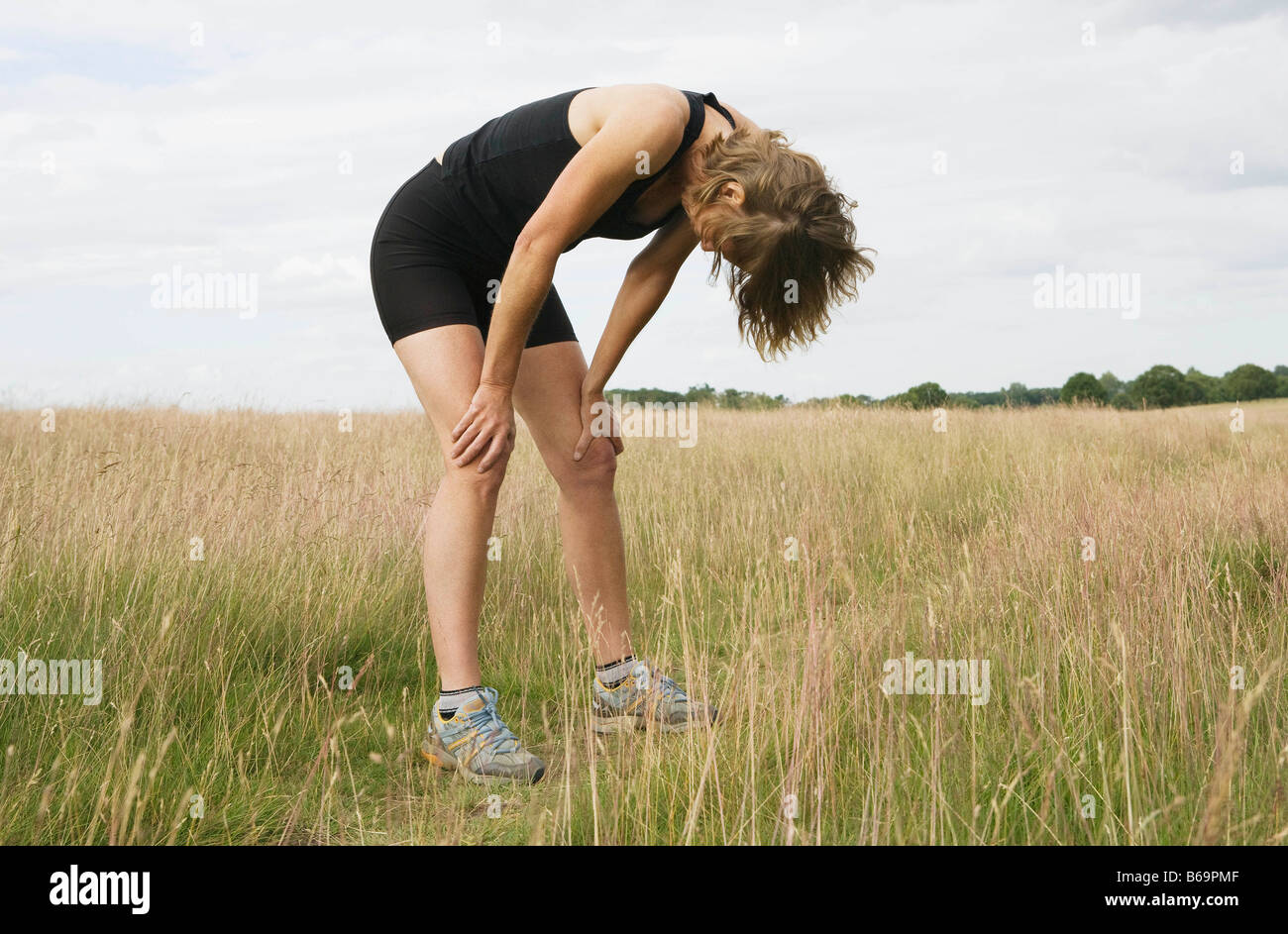 Exhausted woman runner resting Stock Photo - Alamy