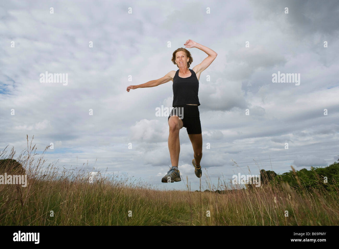 Woman running on dirt track Stock Photo - Alamy