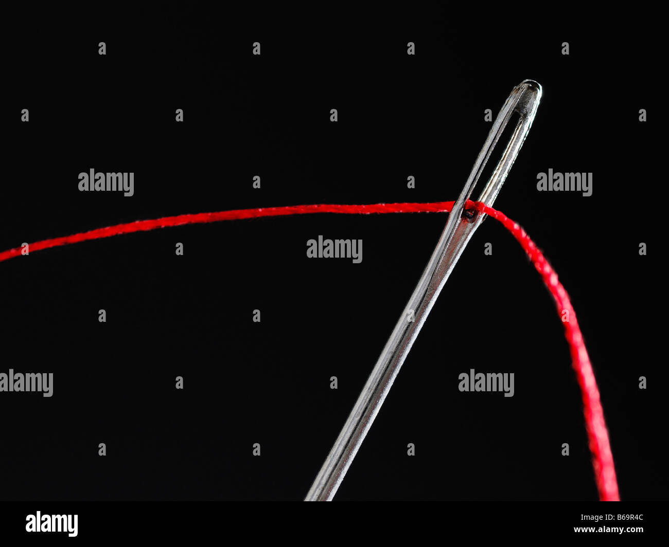 Thread Through the Eye of a Needle Close Up Stock Photo - Alamy