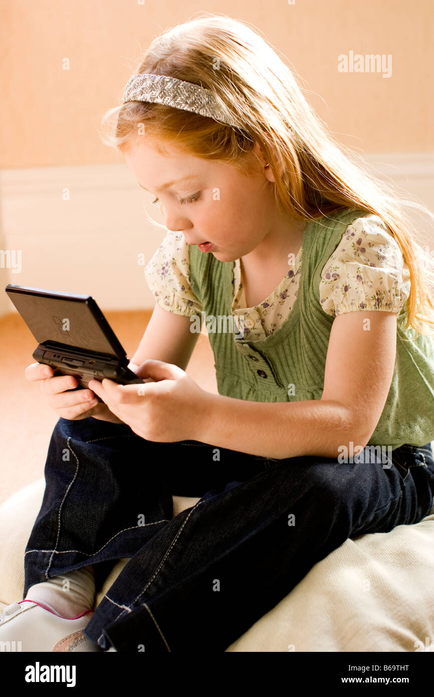 little girl playing a handheld computer game Stock Photo - Alamy