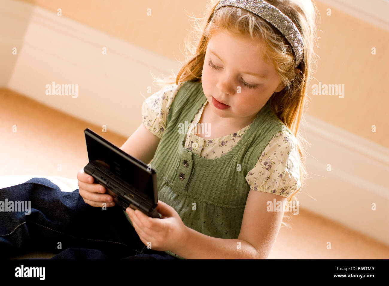 little girl playing a handheld computer game Stock Photo - Alamy