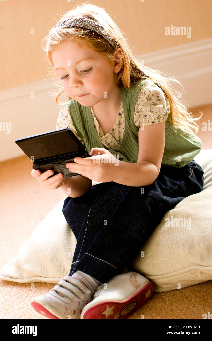 little girl playing a handheld computer game Stock Photo - Alamy