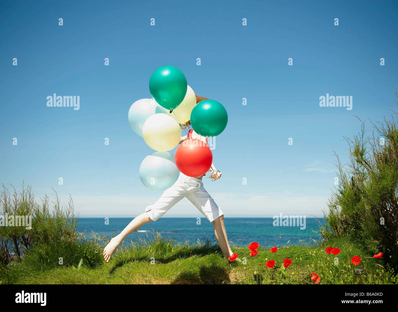 Young girl running with balloons Stock Photo - Alamy