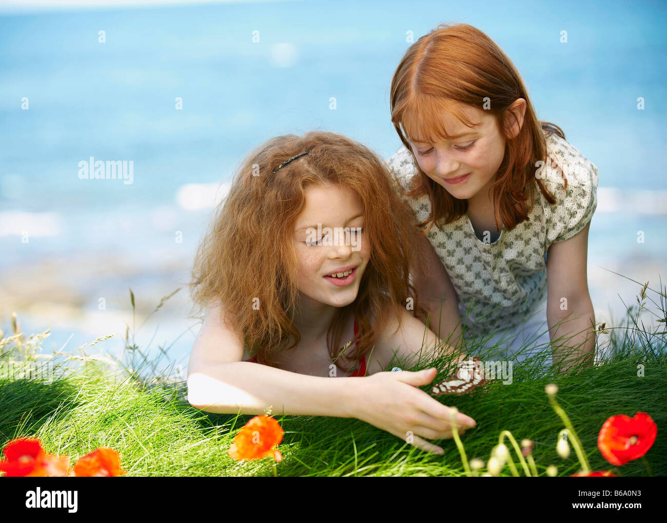 2 girls watching butterfly Stock Photo - Alamy