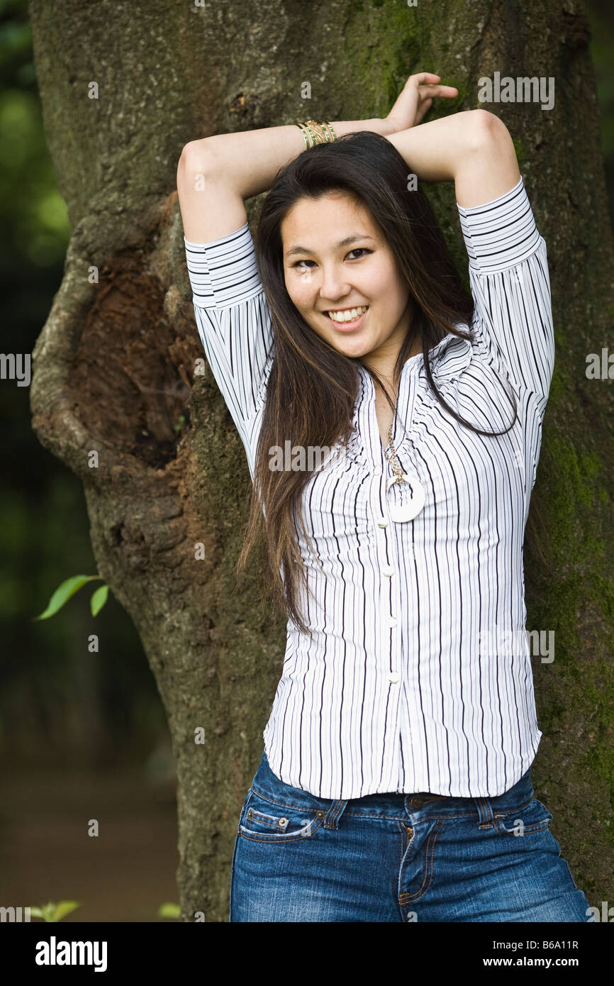 Japanese woman leaning against tree trunk Stock Photo - Alamy