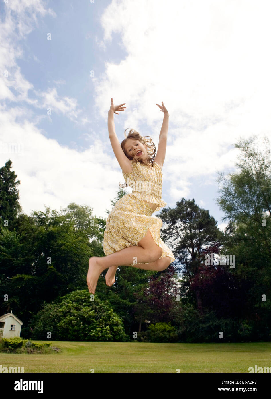 Girl jumping in garden Stock Photo - Alamy
