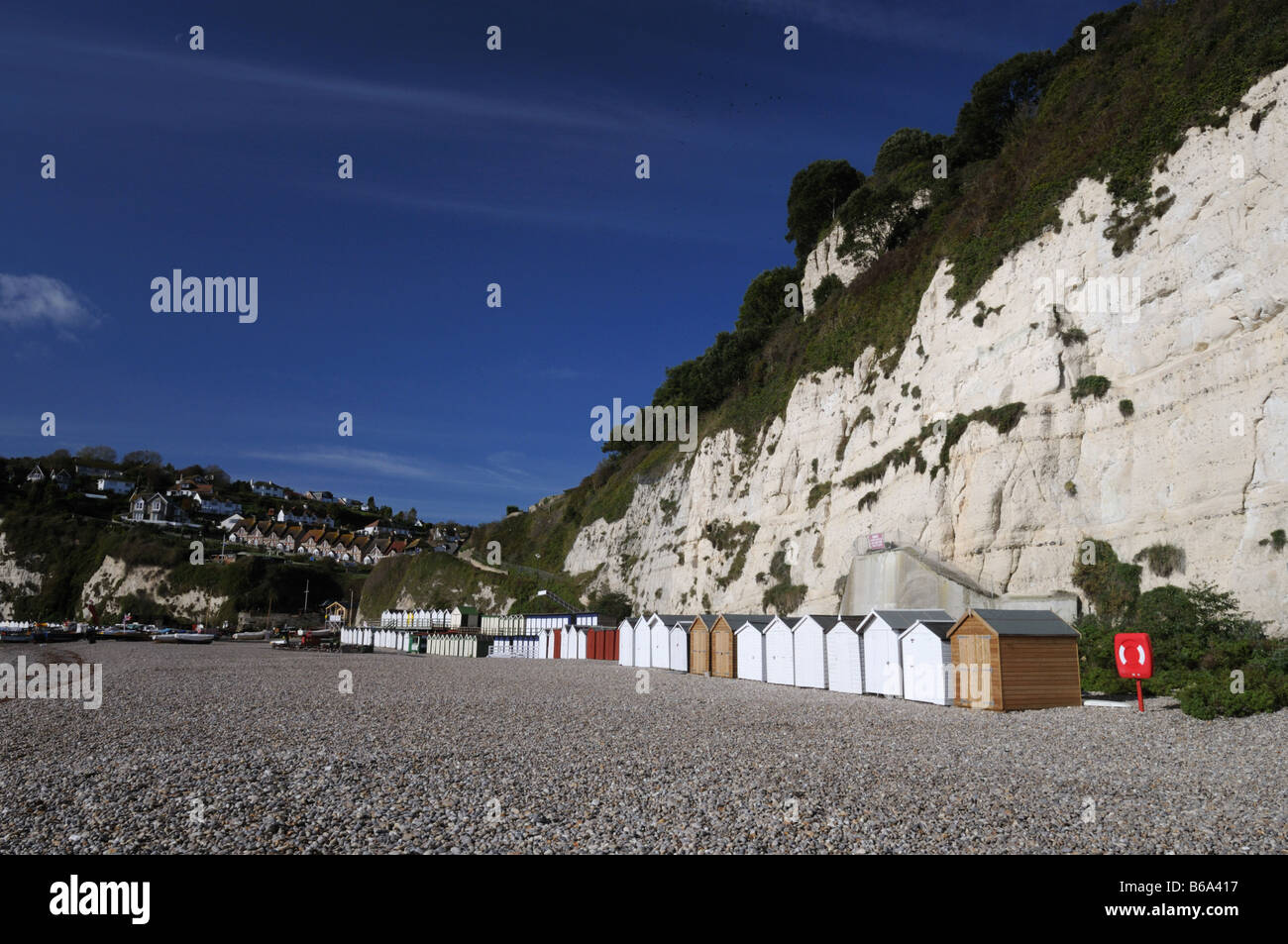 Beach huts and white cliffs at Beer Devon UK Stock Photo - Alamy