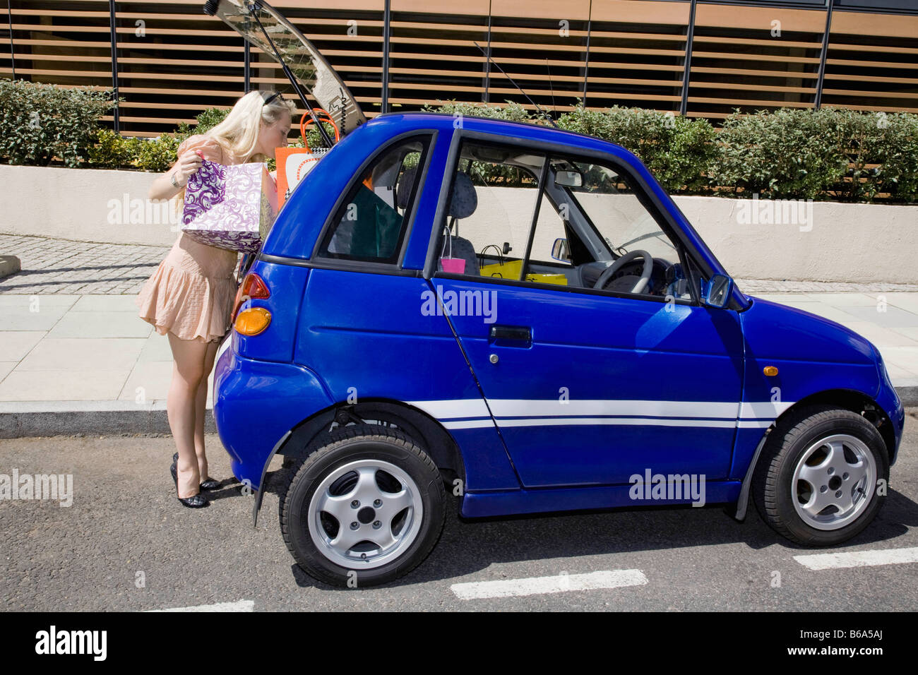 Young woman loading electric car Stock Photo - Alamy