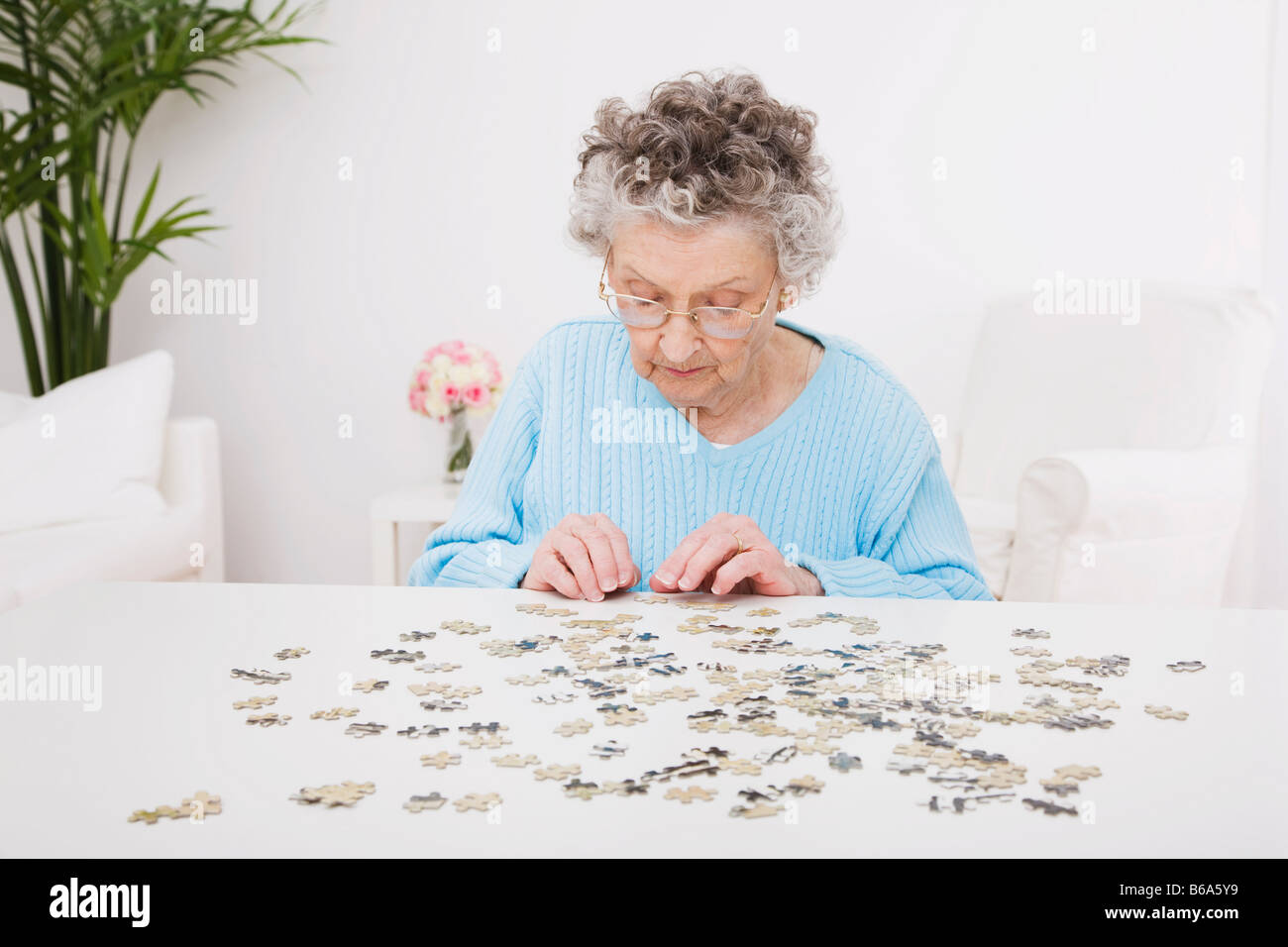 Senior woman doing jigsaw puzzle Stock Photo - Alamy