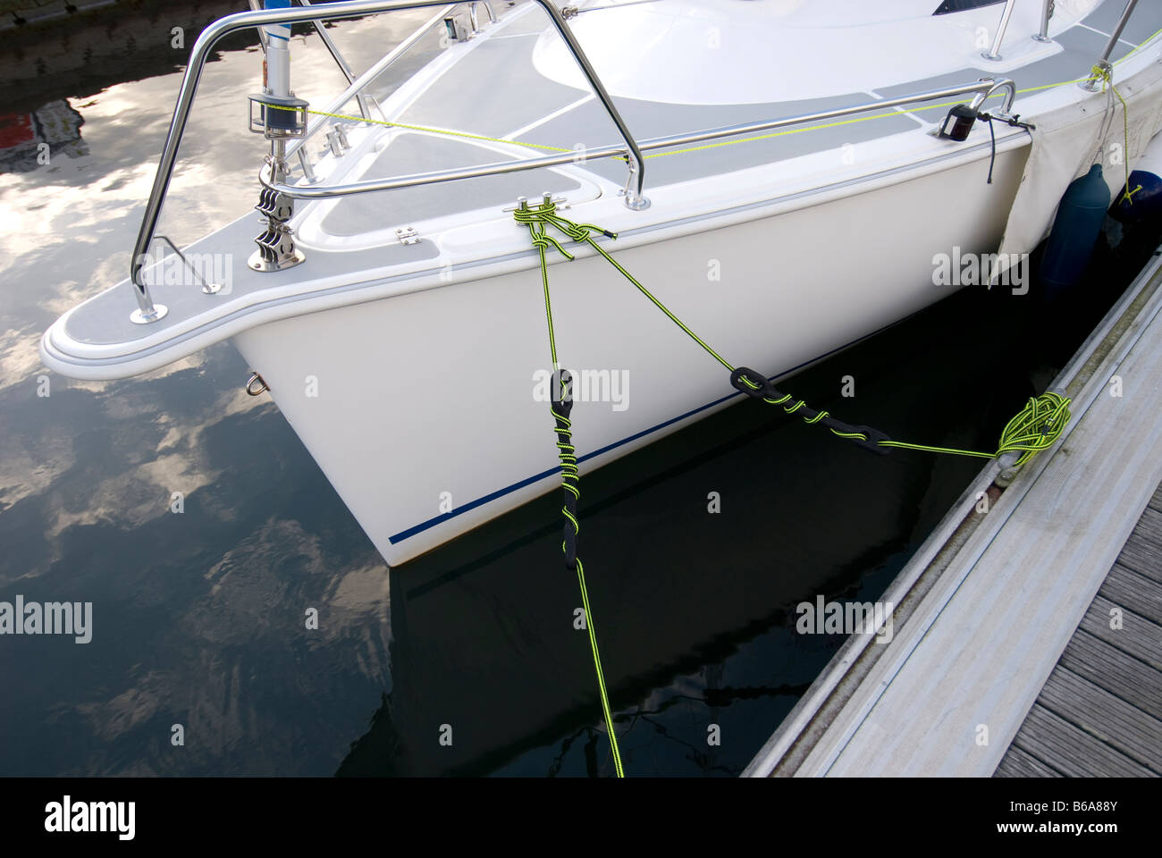 bow of a boat moored alongside a marina using lines fitted with rubber ...