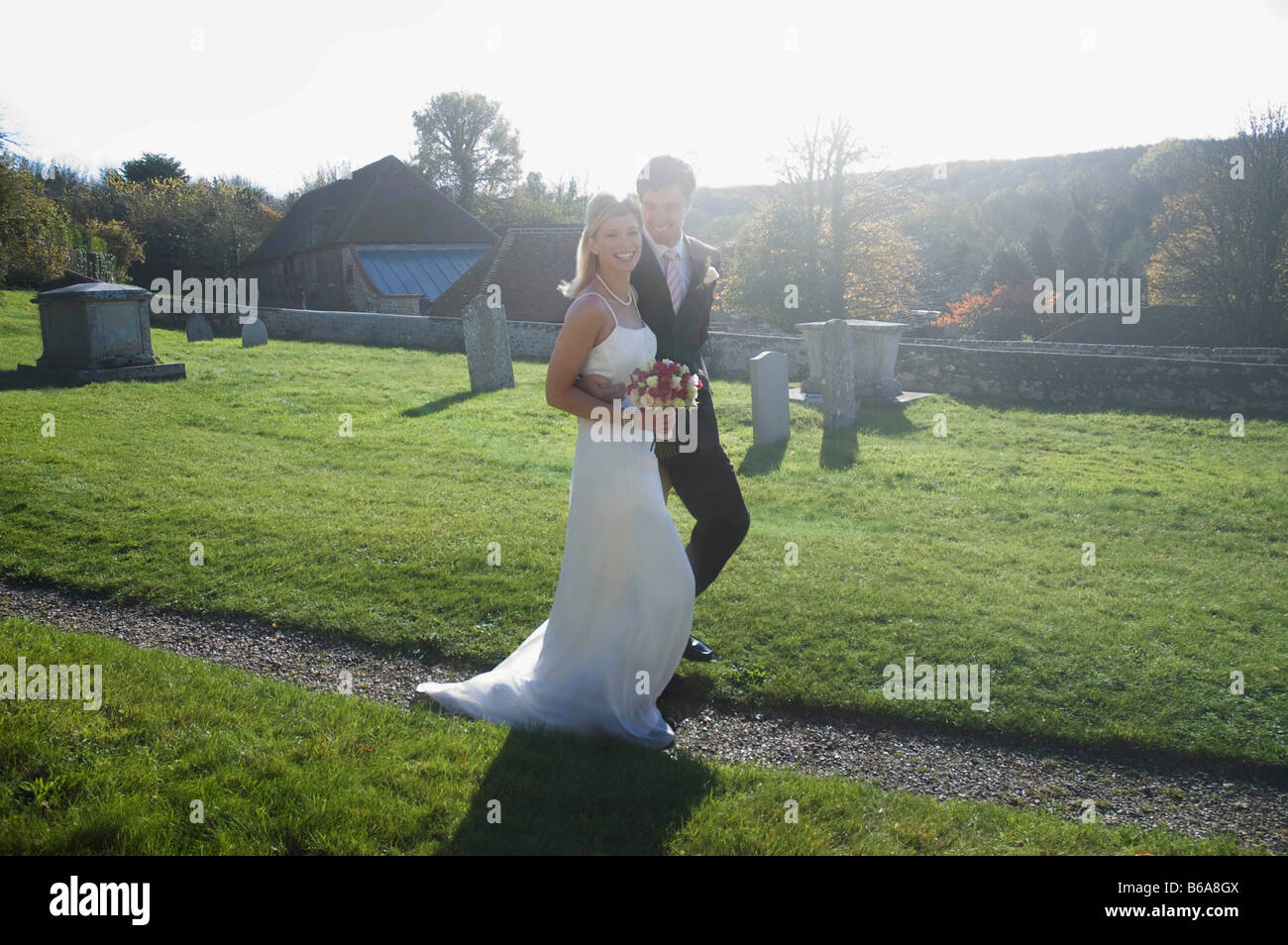 A wedding couple walking along a path Stock Photo - Alamy