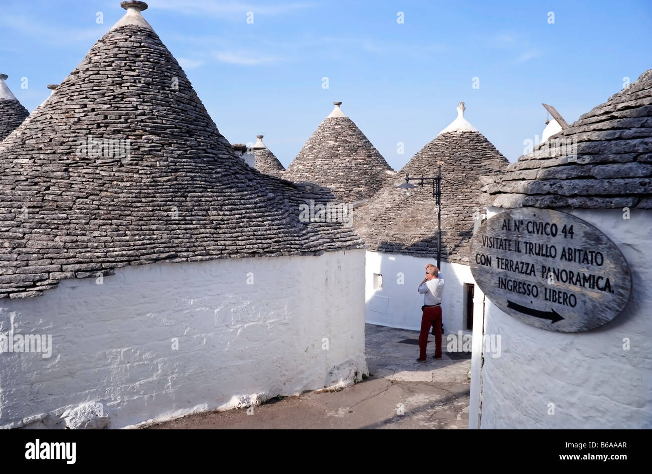 Photographer in street with trullo houses; Alberobello, province of ...