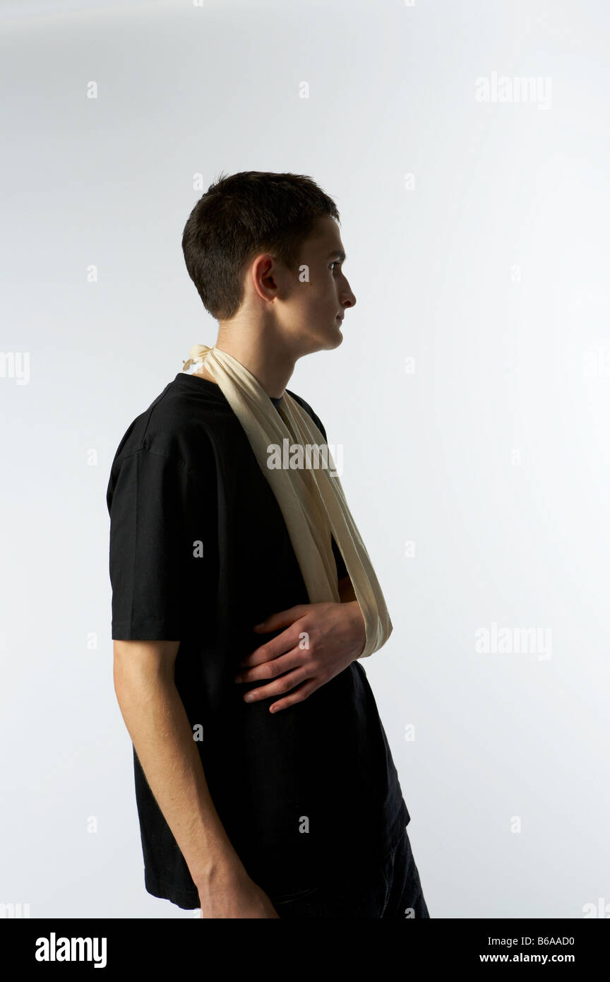 A teenager with a sling on his arm shot in a studio Stock Photo - Alamy