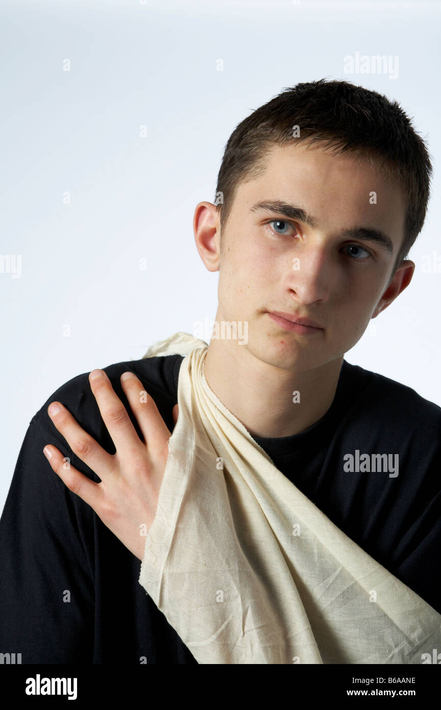 A teenager with a sling on his arm shot in a studio Stock Photo - Alamy