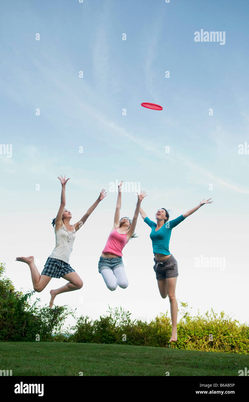 Teenage girls jump to catch a frisbee Stock Photo - Alamy
