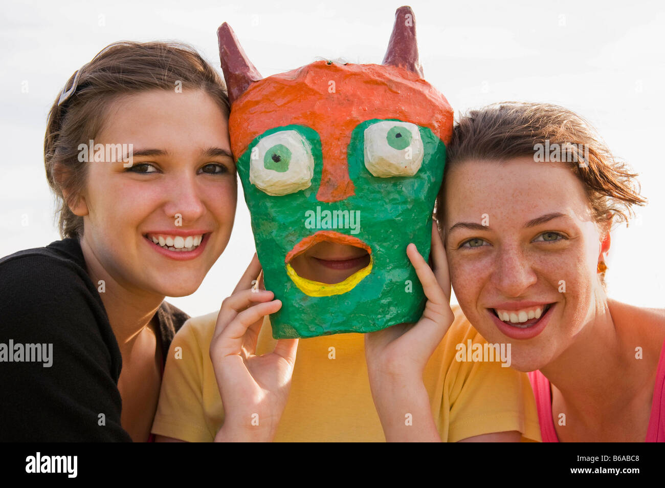Three girls, one wearing a mask Stock Photo - Alamy
