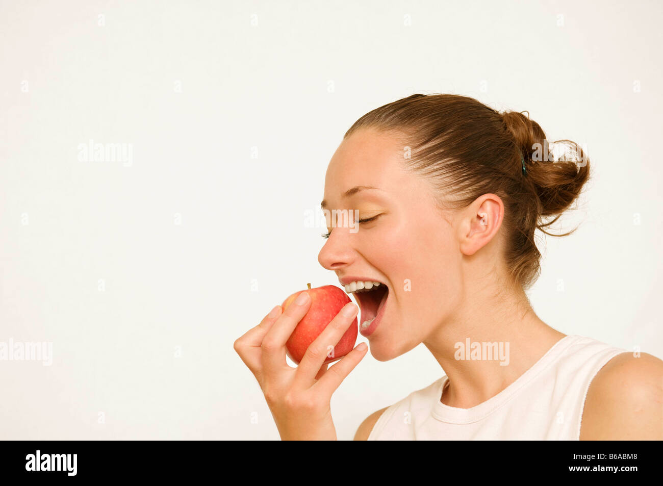 Girl eating a red apple Stock Photo - Alamy