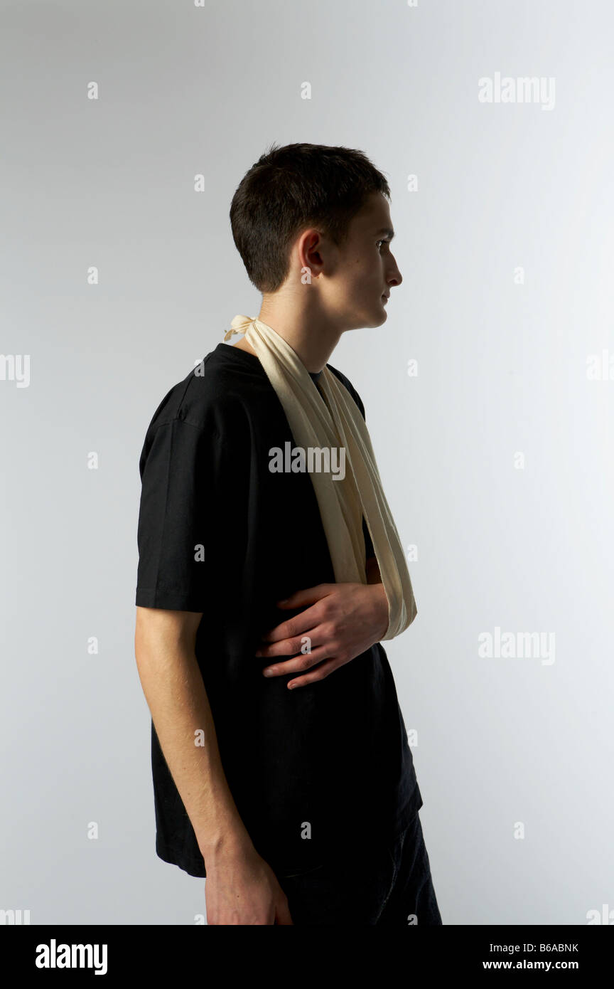 A teenager with a sling on his arm shot in a studio Stock Photo - Alamy