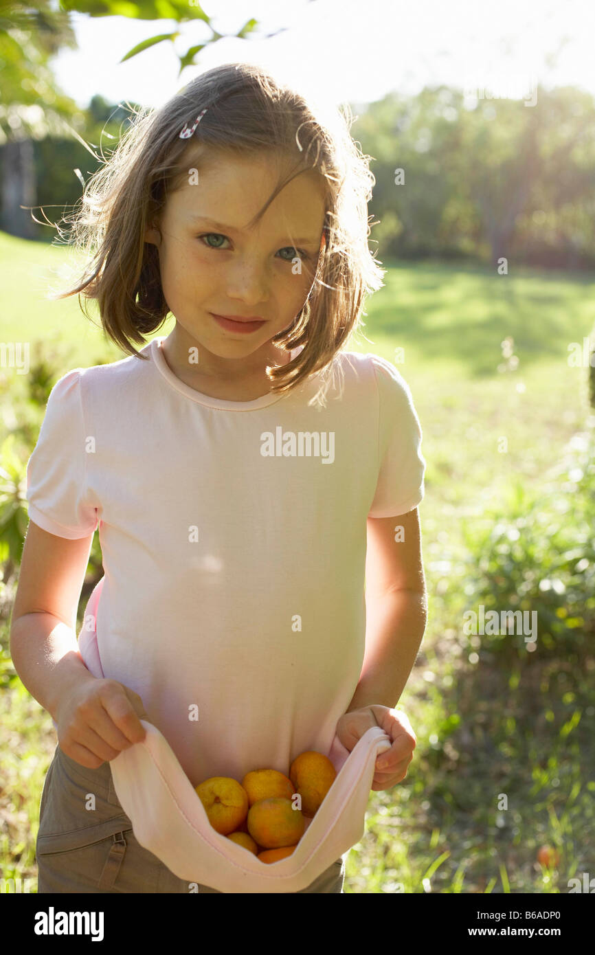 Young girl outside collecting fruit Stock Photo - Alamy