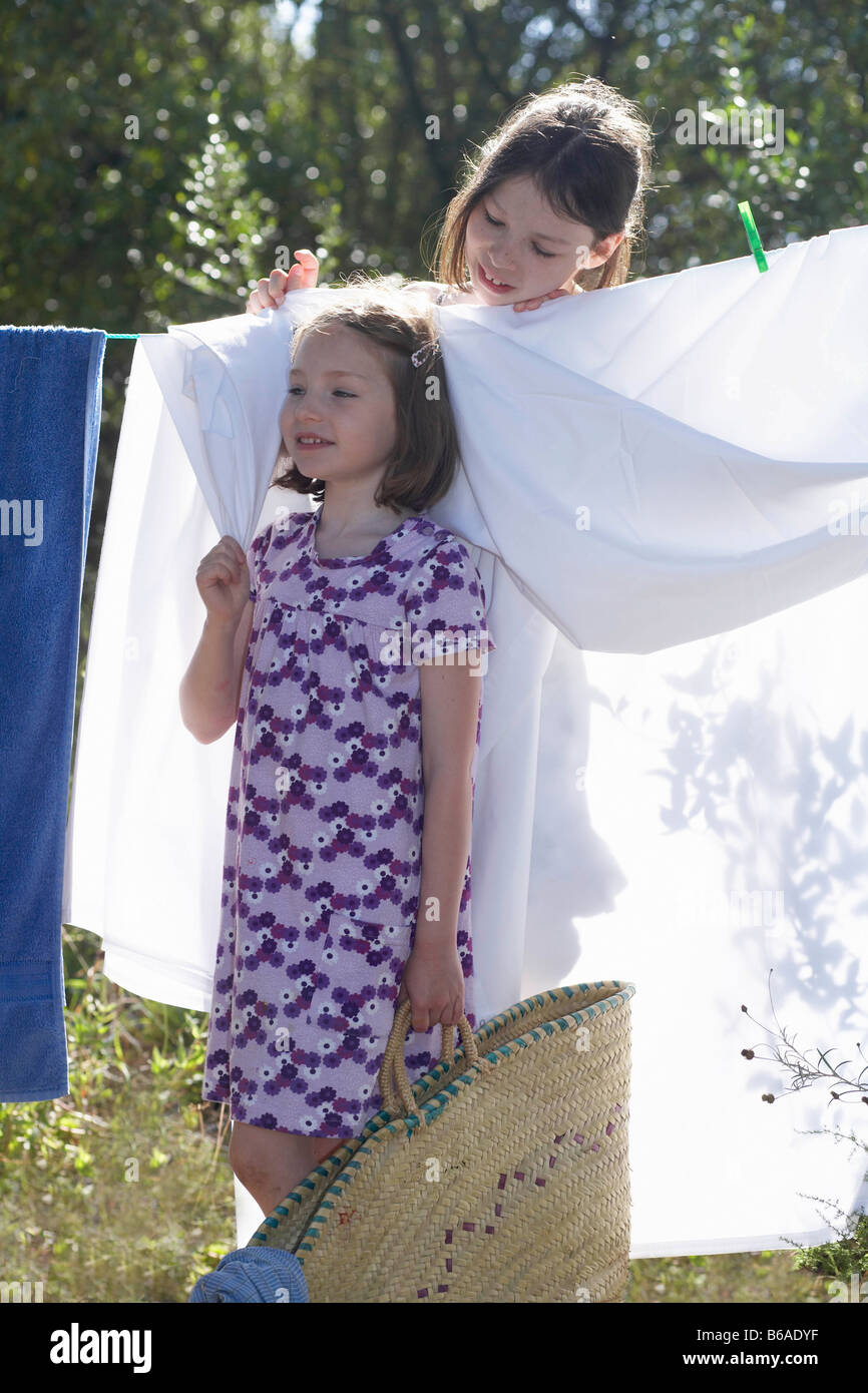 Young girls standing by washing line Stock Photo - Alamy