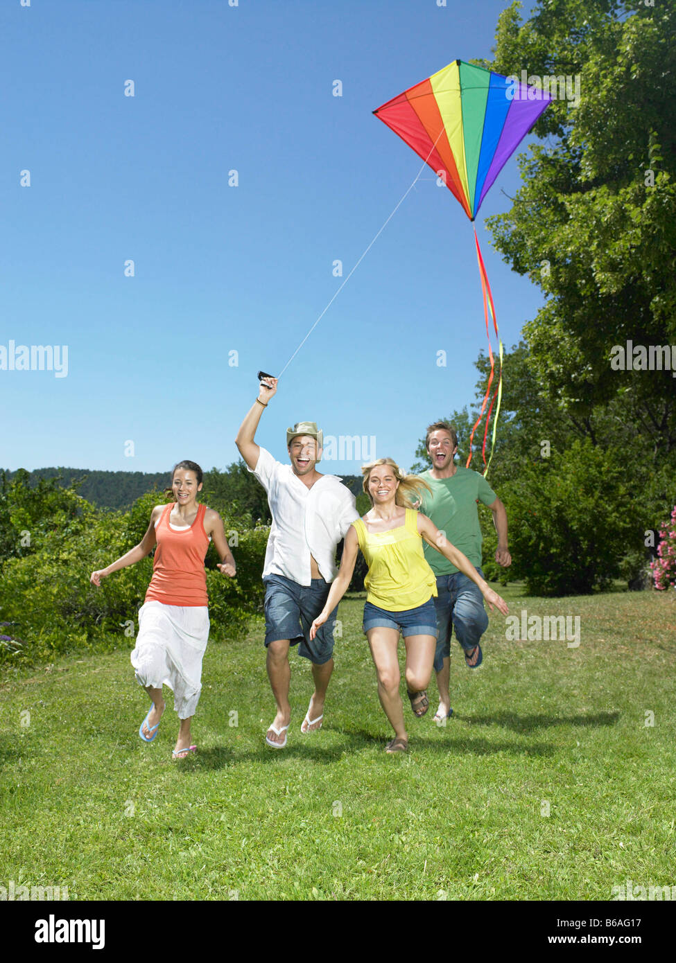 Friends flying a kite Stock Photo - Alamy
