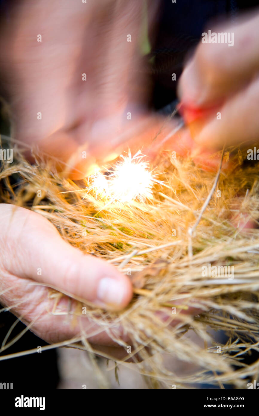 Striking firesteel to create sparks to light kindling Stock Photo - Alamy