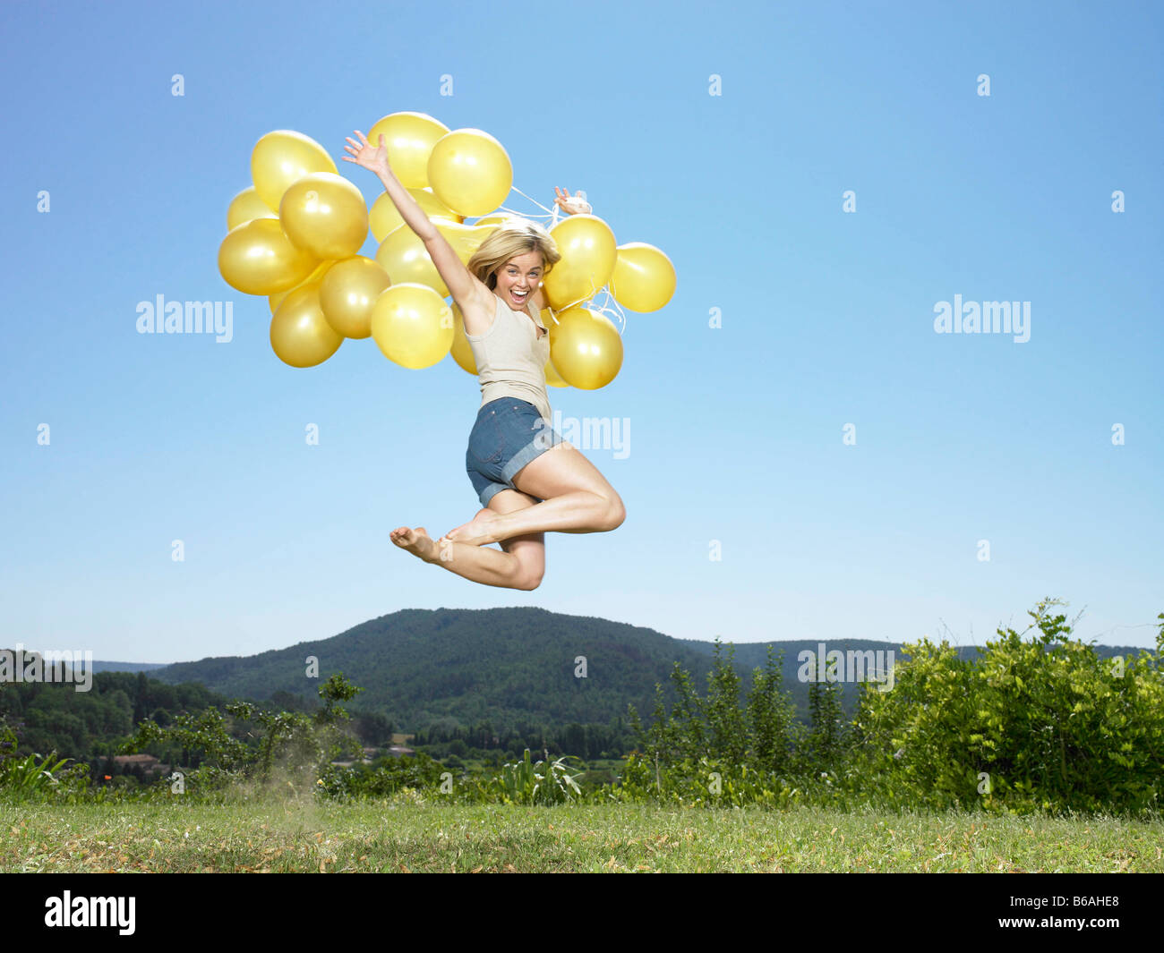 Girl jumping with balloons Stock Photo - Alamy