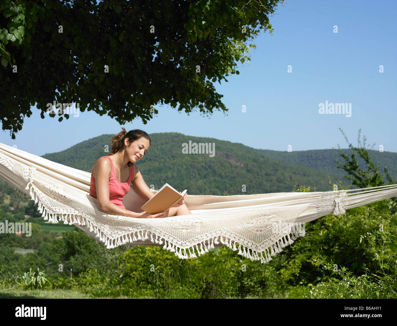 Girl reading in hammock Stock Photo - Alamy