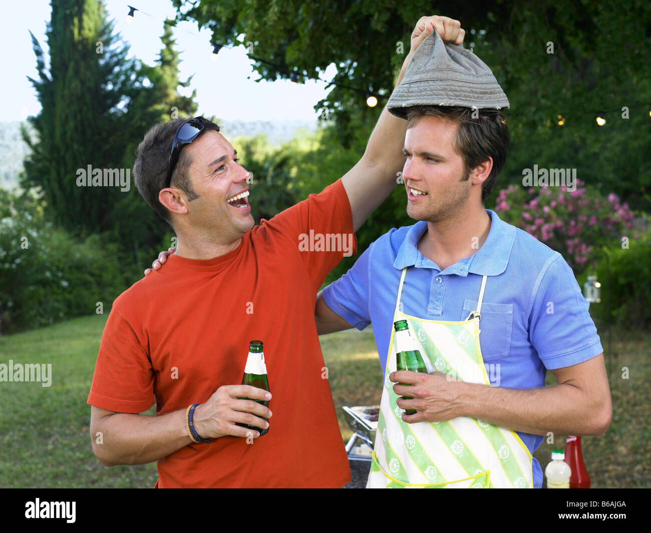 Two men laughing at barbecue Stock Photo - Alamy