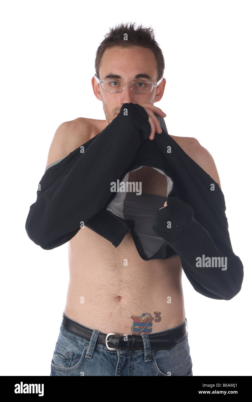 Young man putting shirt on Stock Photo - Alamy