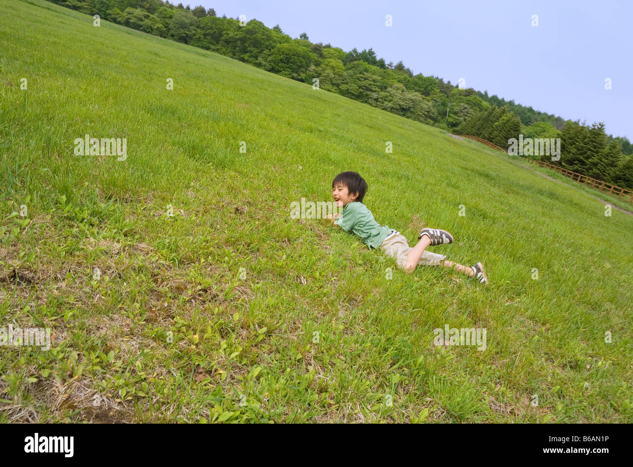 Boy lying on grass field Stock Photo - Alamy