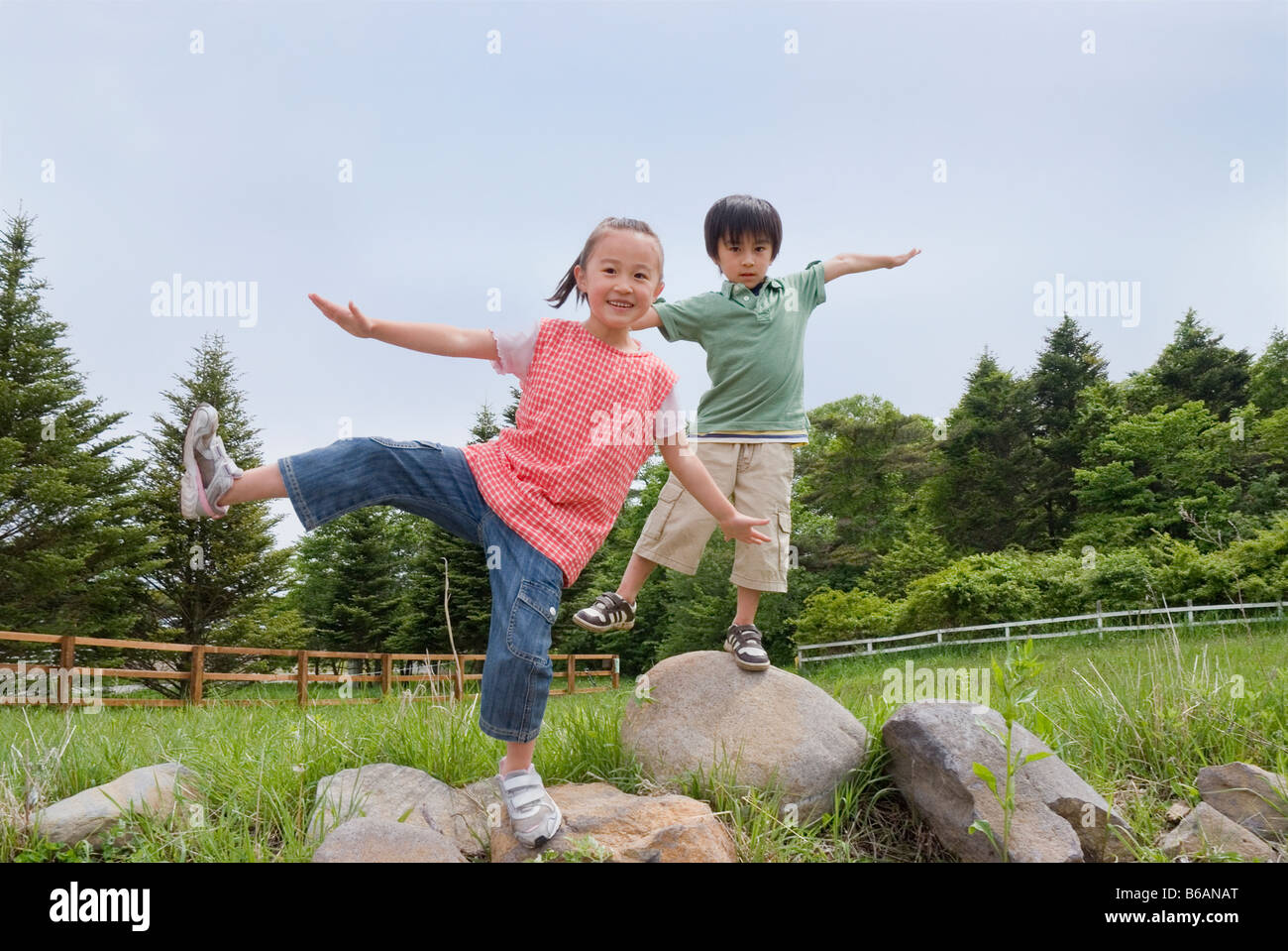 Boy and girl balancing on rocks Stock Photo - Alamy