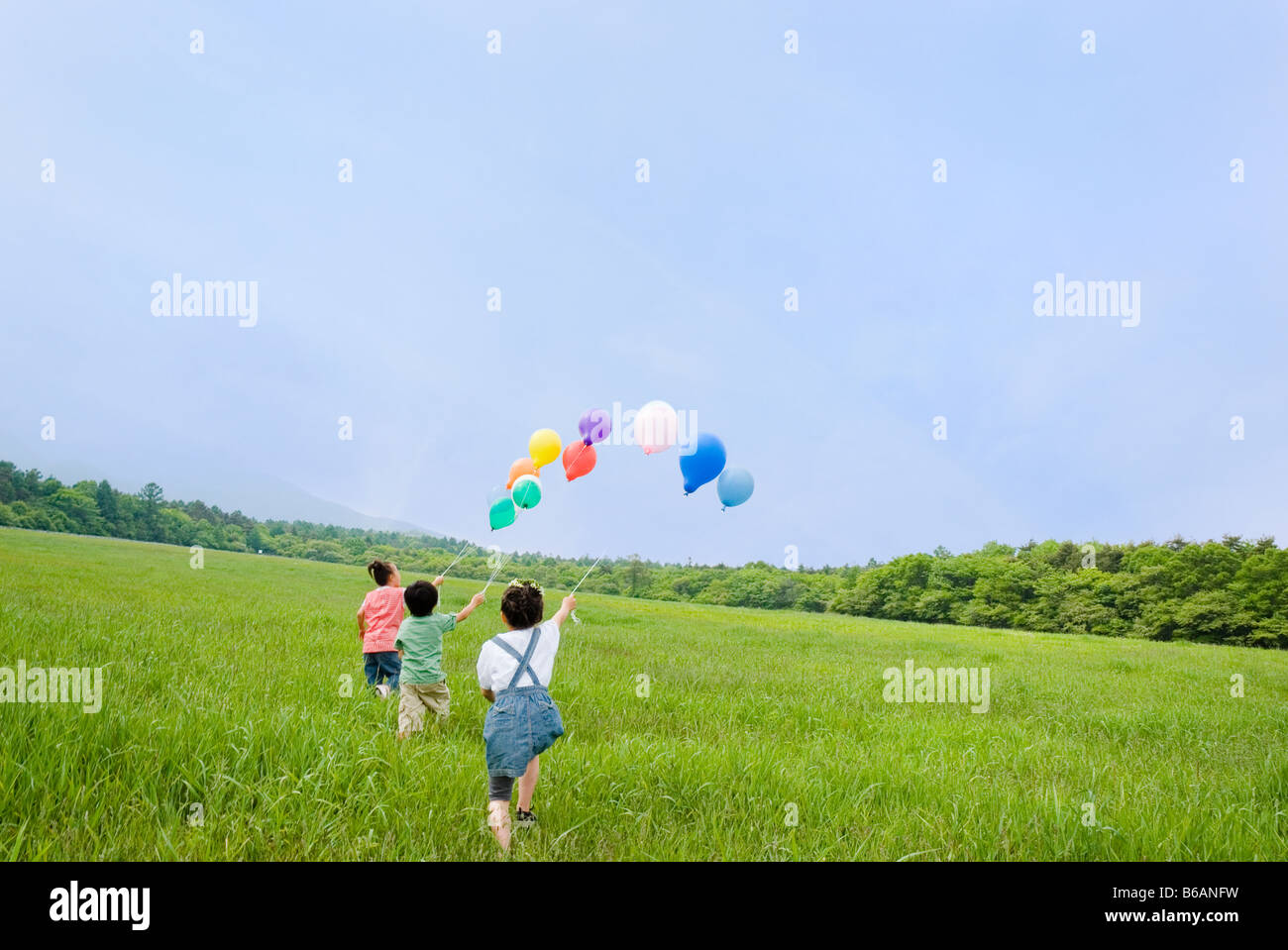 Children running with balloons Stock Photo - Alamy