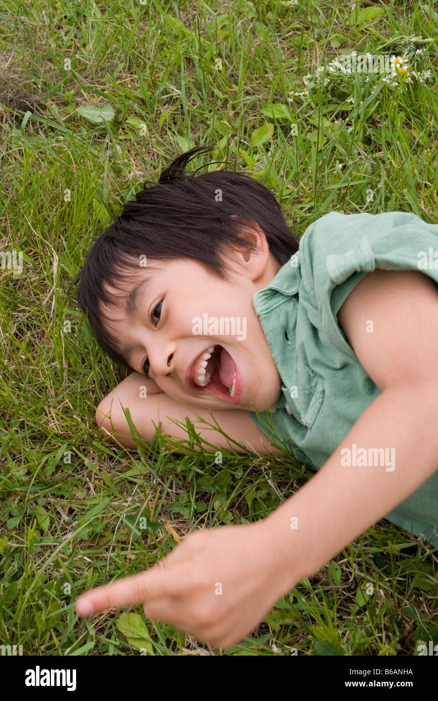 Boy lying on grass field Stock Photo - Alamy