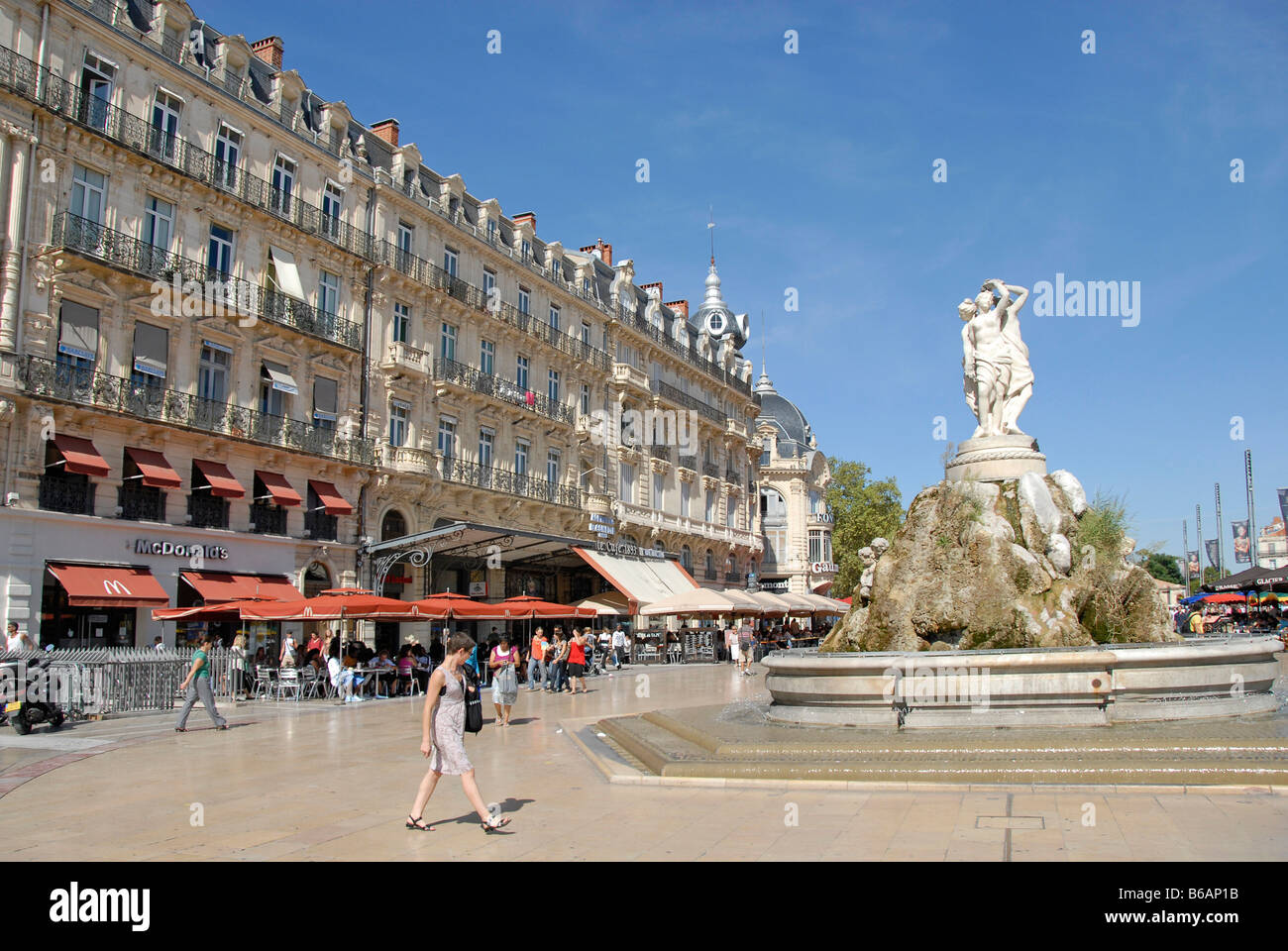 People walking past the fountain on the historic main square "Place de ...