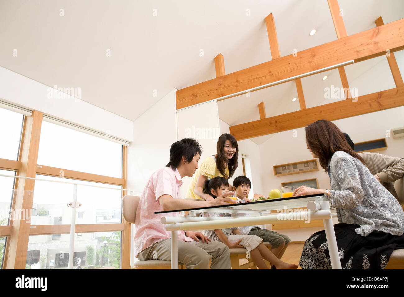 Family sitting at dining table Stock Photo - Alamy