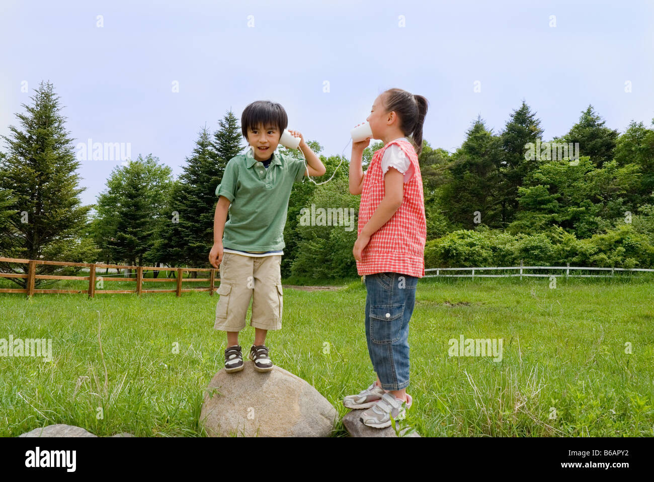 Boy and girl talking with string telephone Stock Photo - Alamy