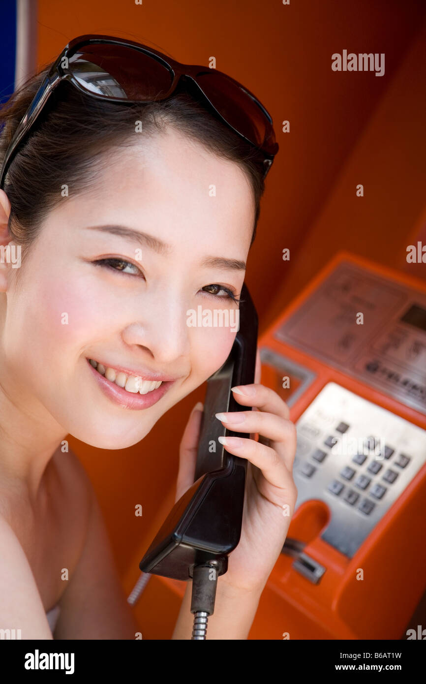 Young woman using public phone Stock Photo - Alamy