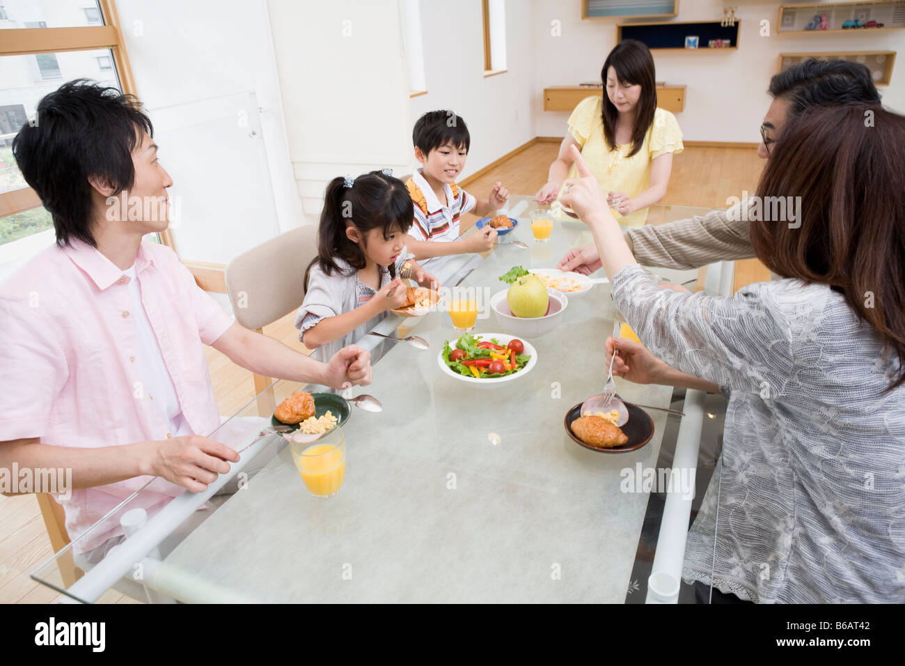 Family sitting at dining table Stock Photo - Alamy