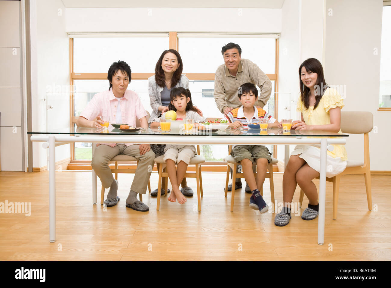 Family sitting at dining table Stock Photo - Alamy