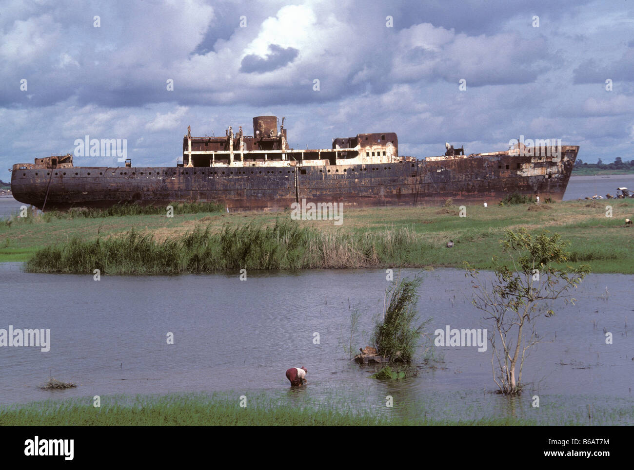 A beached and abandoned freighter lies in a river in Phnom Penh ...