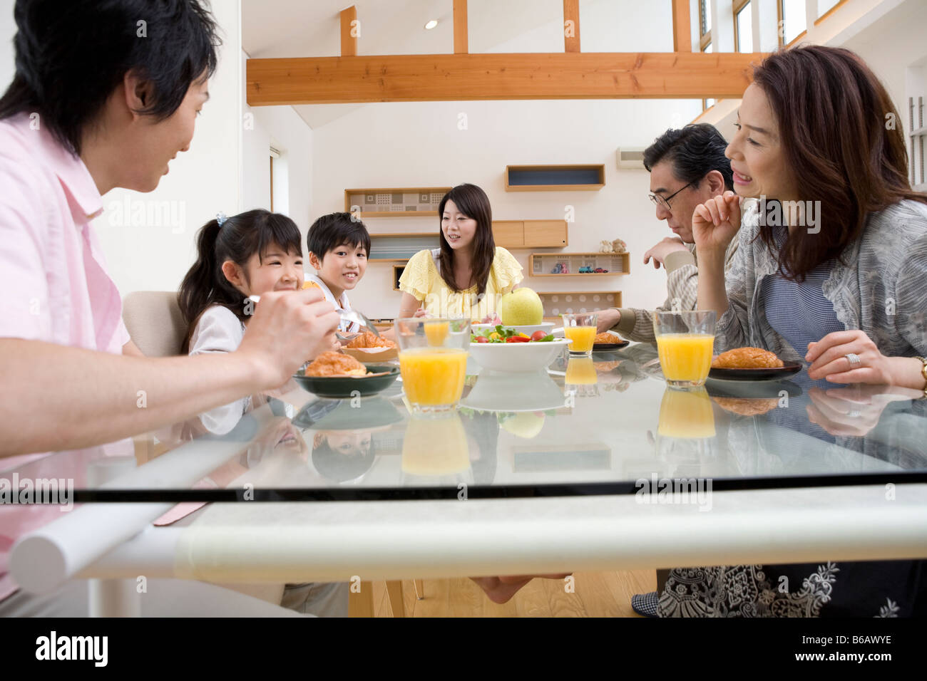 Family sitting at dining table Stock Photo - Alamy