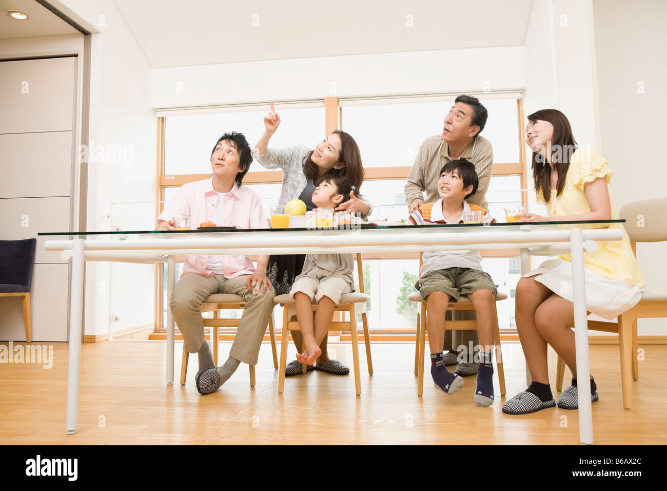 Family sitting at dining table Stock Photo - Alamy
