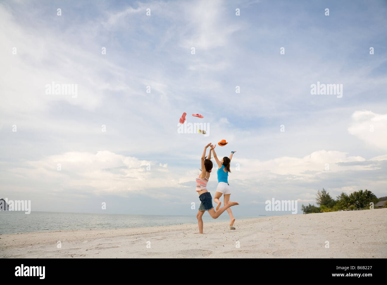 Two young women throwing flip flop Stock Photo - Alamy