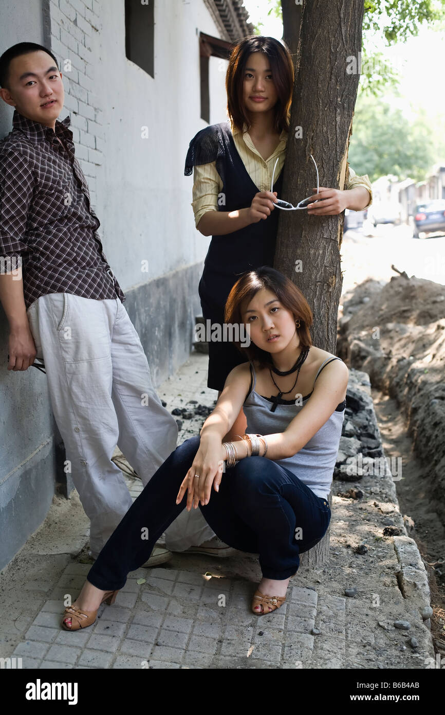 Chinese friends standing on sidewalk Stock Photo - Alamy
