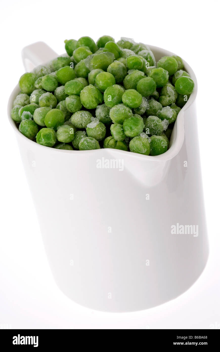 FROZEN ORGANIC PETITS POIS IN A WHITE JUG ON WHITE BACKGROUND Stock ...