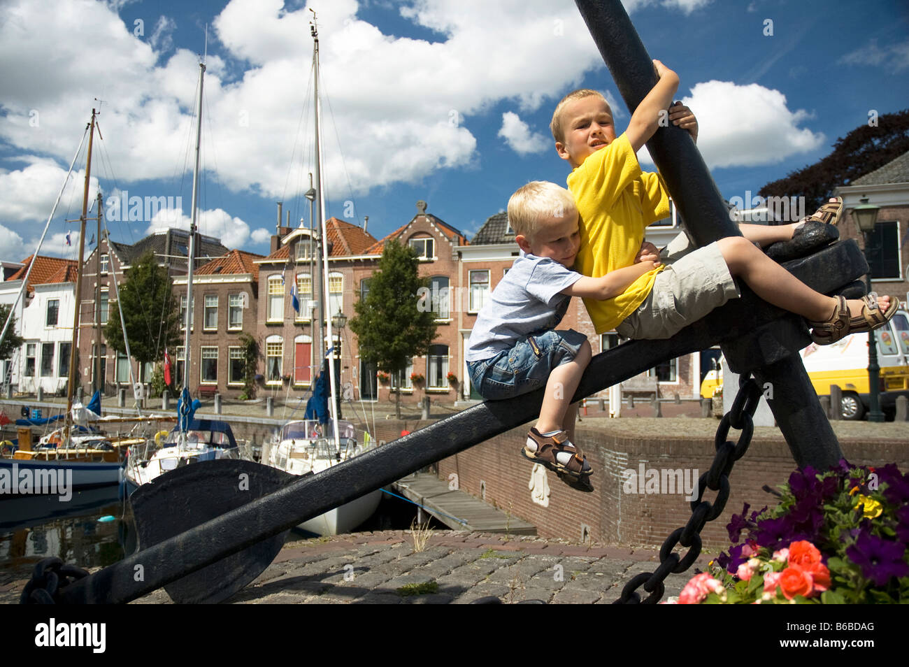 Two boys on an anchor in front of a beautiful harbor Stock Photo - Alamy