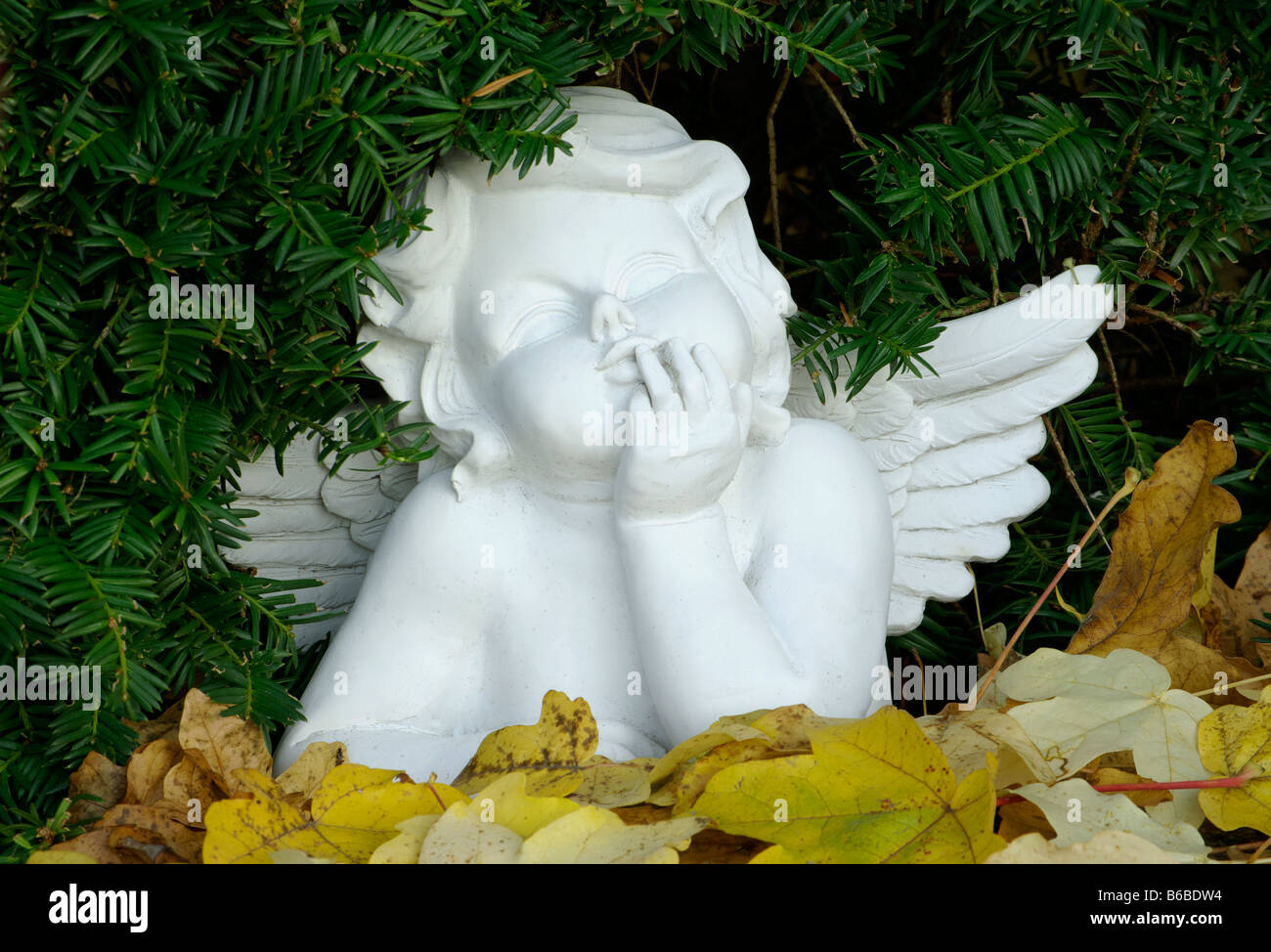 angel sculpture statue thinking amid autumn leaves Stock Photo - Alamy