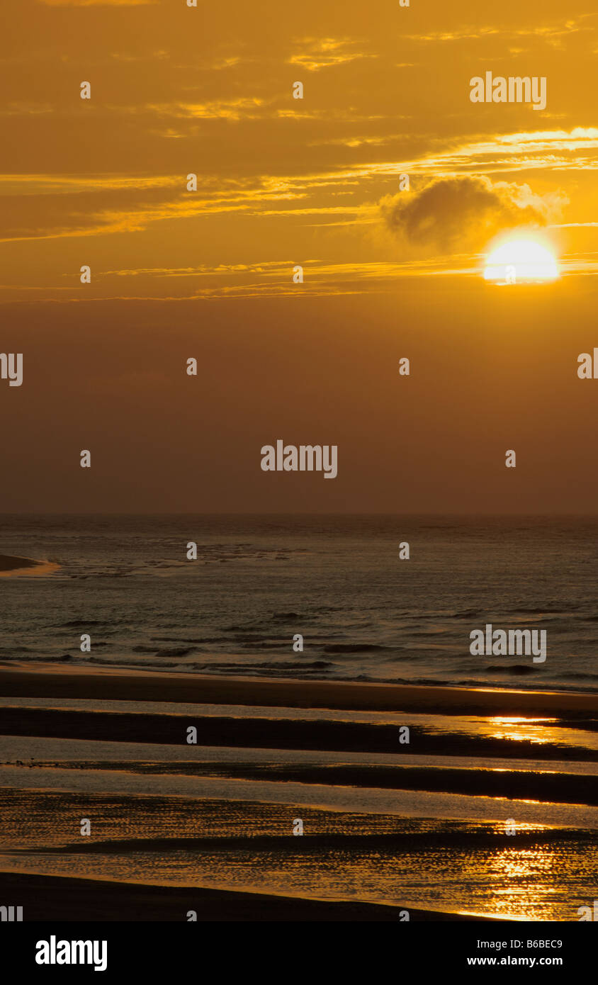 sunset with sea and incoming tide and waves Stock Photo - Alamy