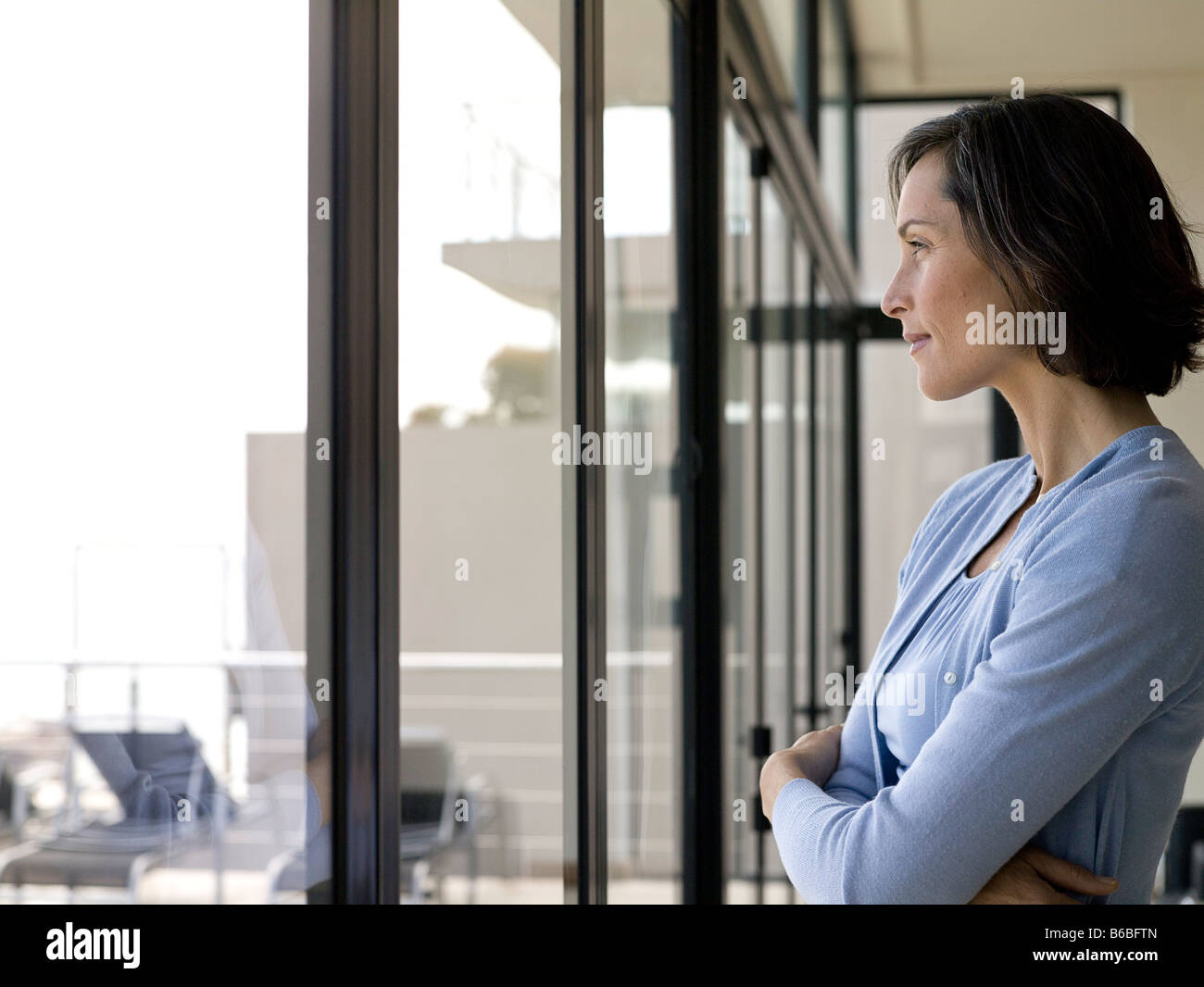 Side profile of woman looking through window Stock Photo - Alamy